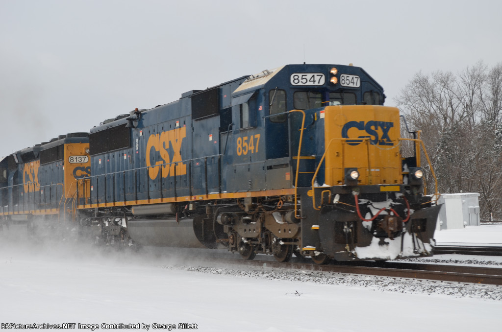 CSX 8547 kicks up snow as she speeds east.